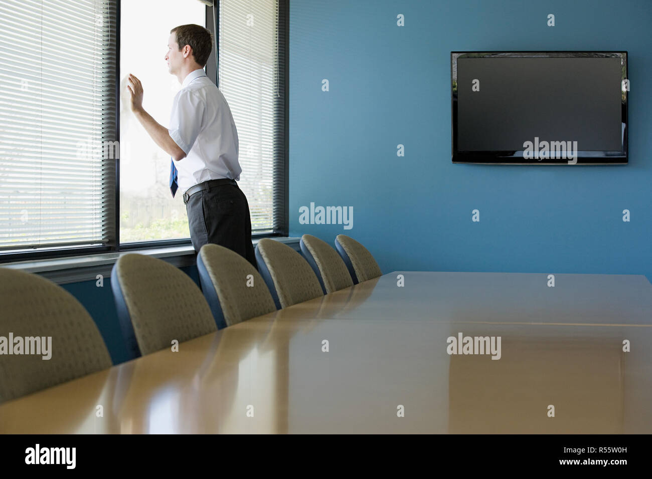 Office worker looking through window Stock Photo - Alamy