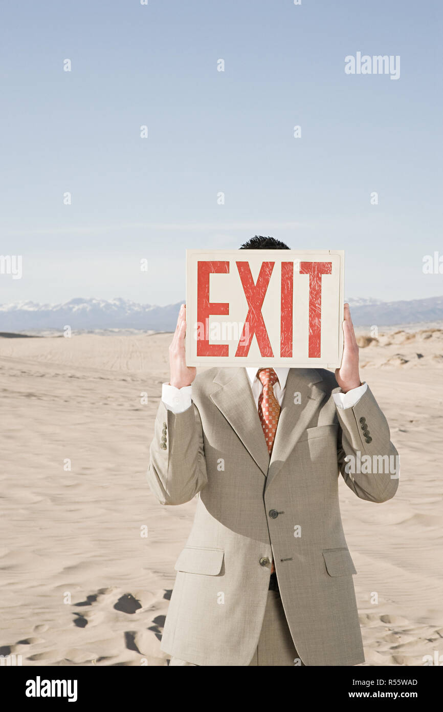 Man in desert with exit sign Stock Photo - Alamy