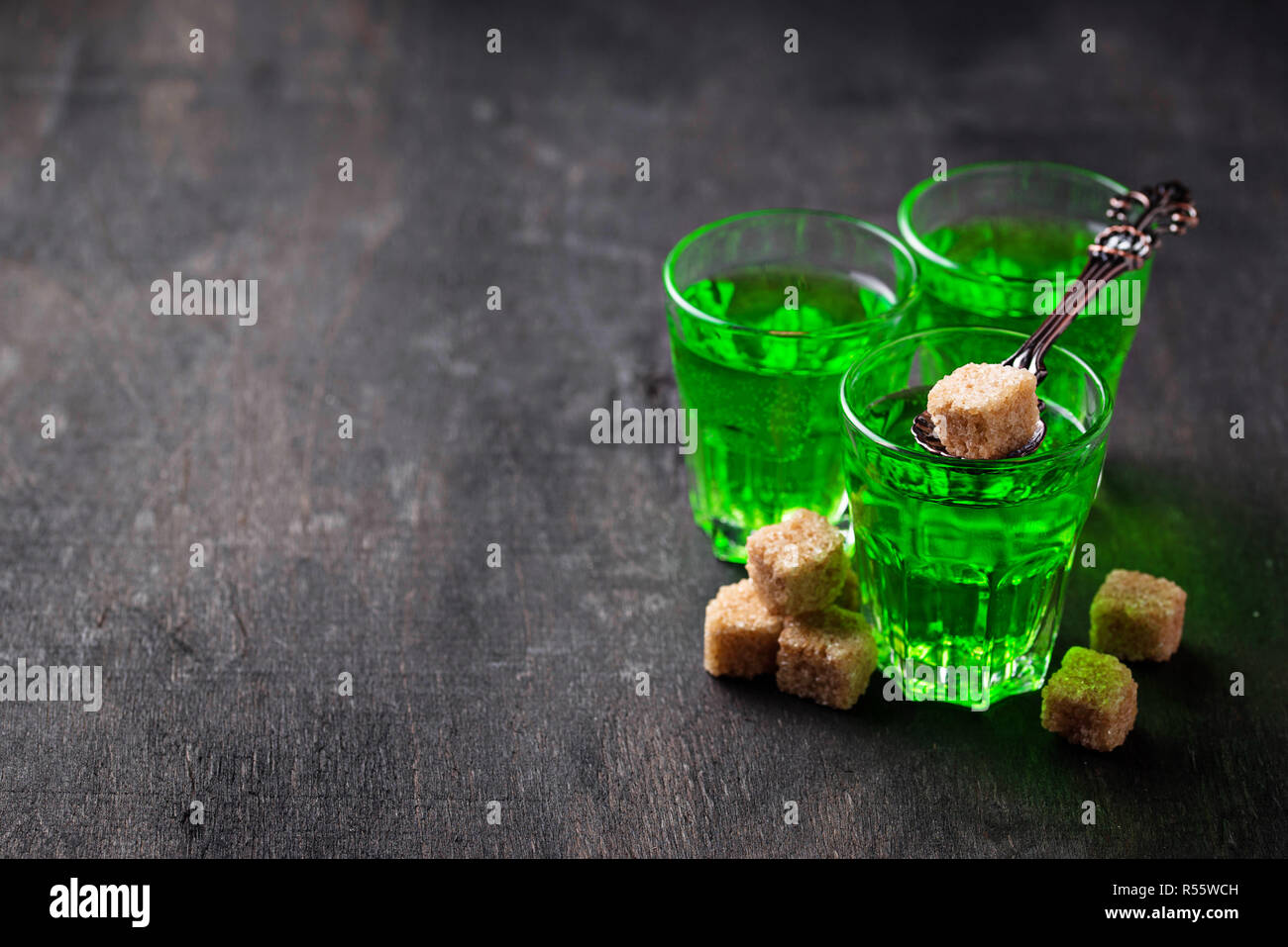 Glasses of green alcoholic drink absinthe with brown sugar Stock Photo ...