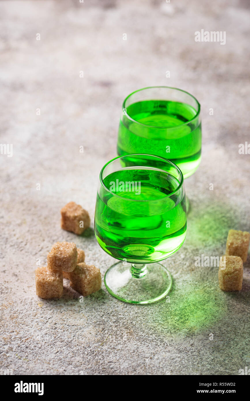 Glasses of green alcoholic drink absinthe with brown sugar Stock Photo ...