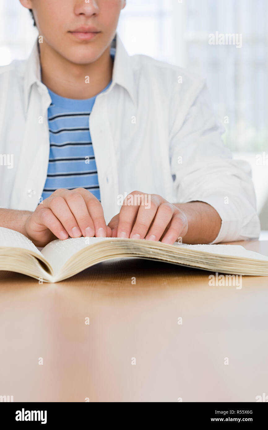 Blind boy reading a braille book Stock Photo - Alamy