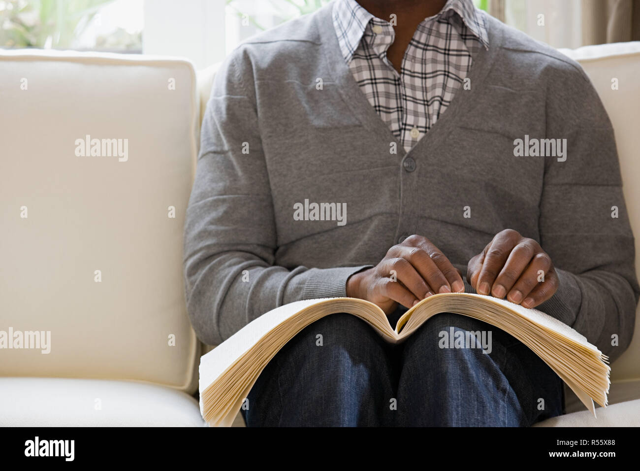 Blind man reading a braille book Stock Photo - Alamy