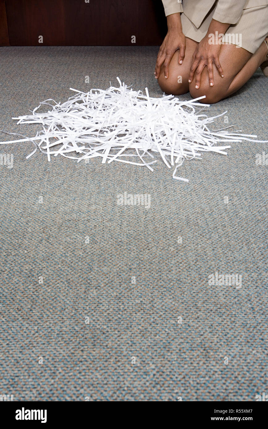 Woman kneeling by shredded paper Stock Photo - Alamy