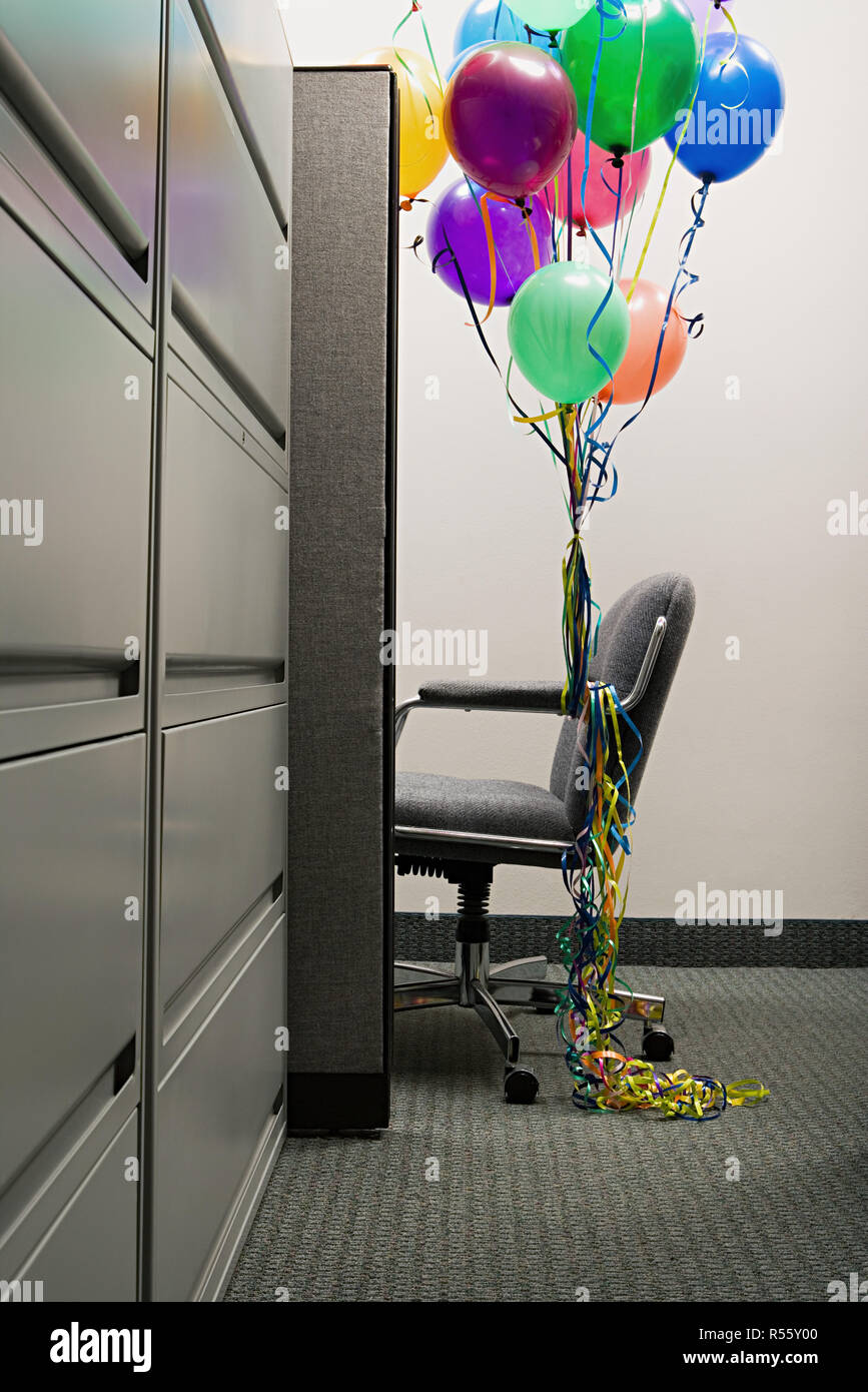 Empty office chair with balloons tied to it Stock Photo - Alamy