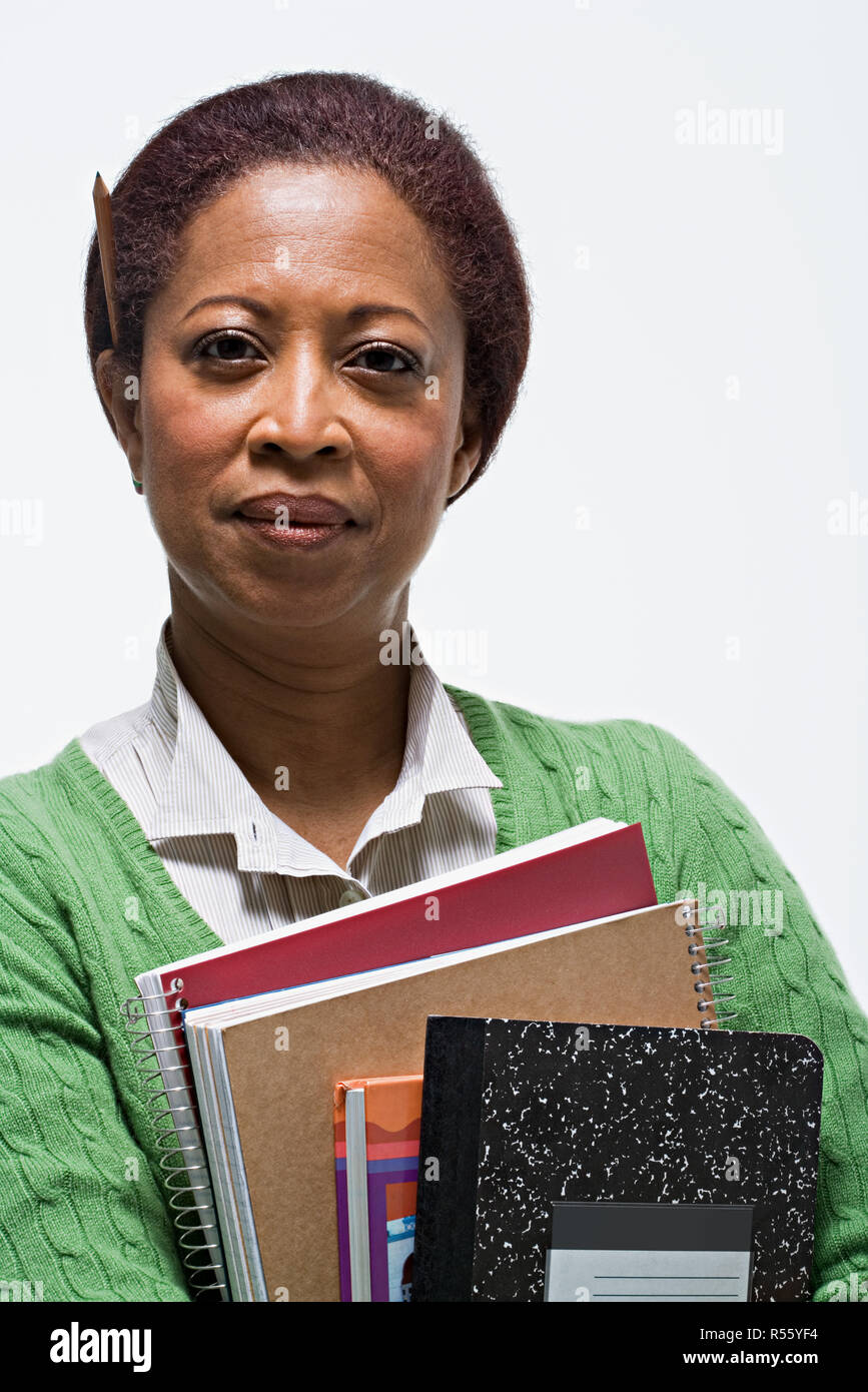 Portrait of teacher holding books Stock Photo - Alamy