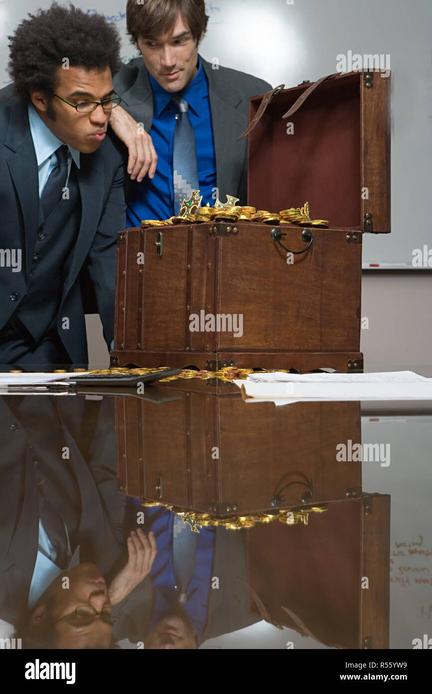 Colleagues looking at a treasure chest Stock Photo - Alamy