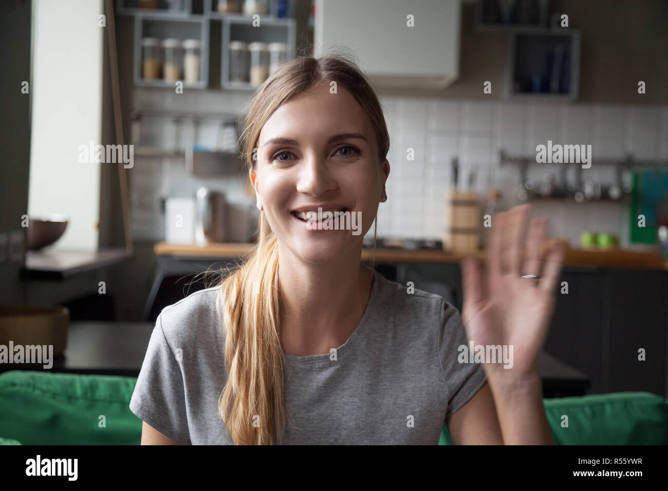 Portrait happy smiling woman waving hand, looking at camera Stock Photo ...