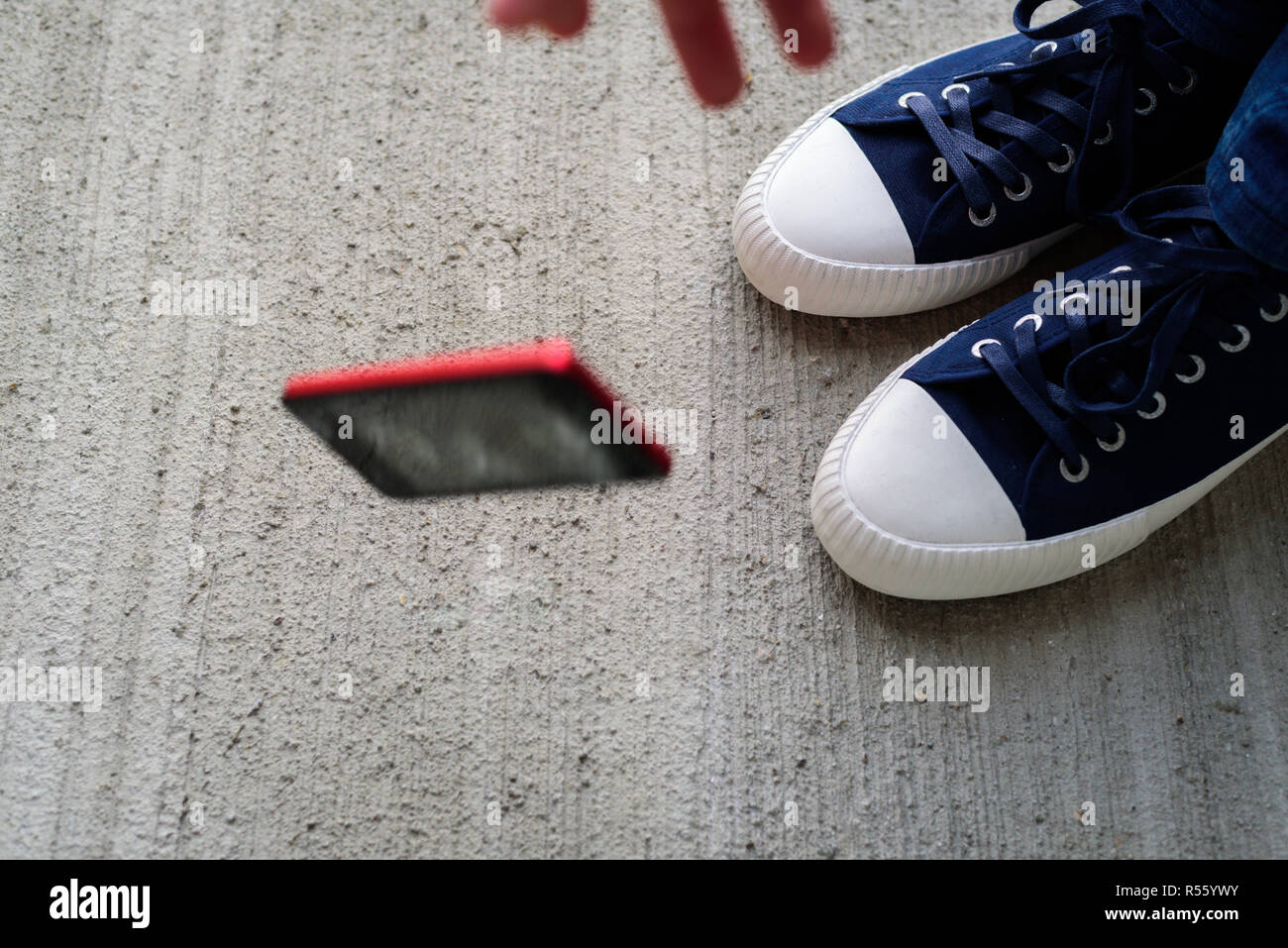 Woman legs in trainers near falling phone cracked screen on concrete ...