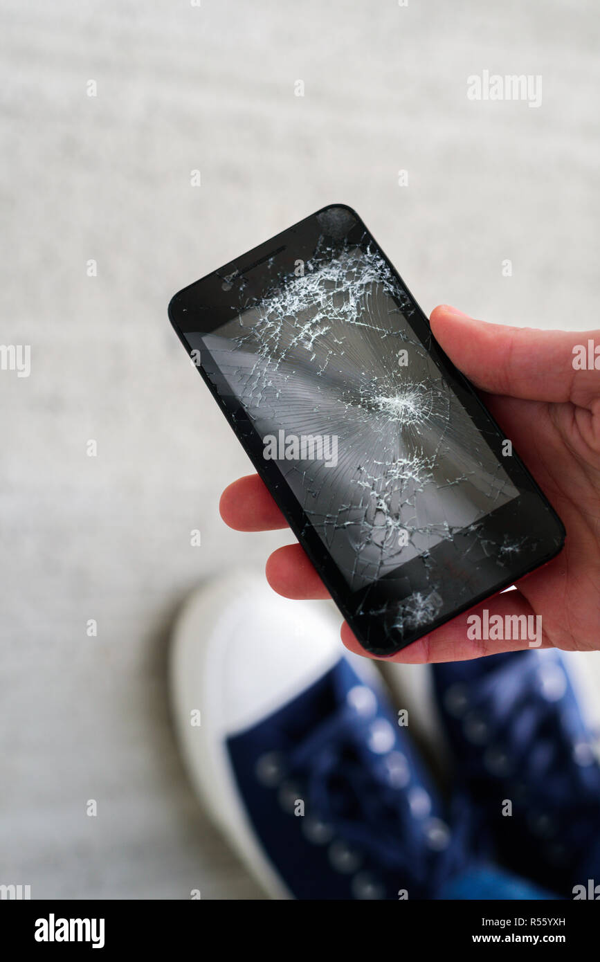 Woman legs in trainers near broken fallen phone cracked screen on ...