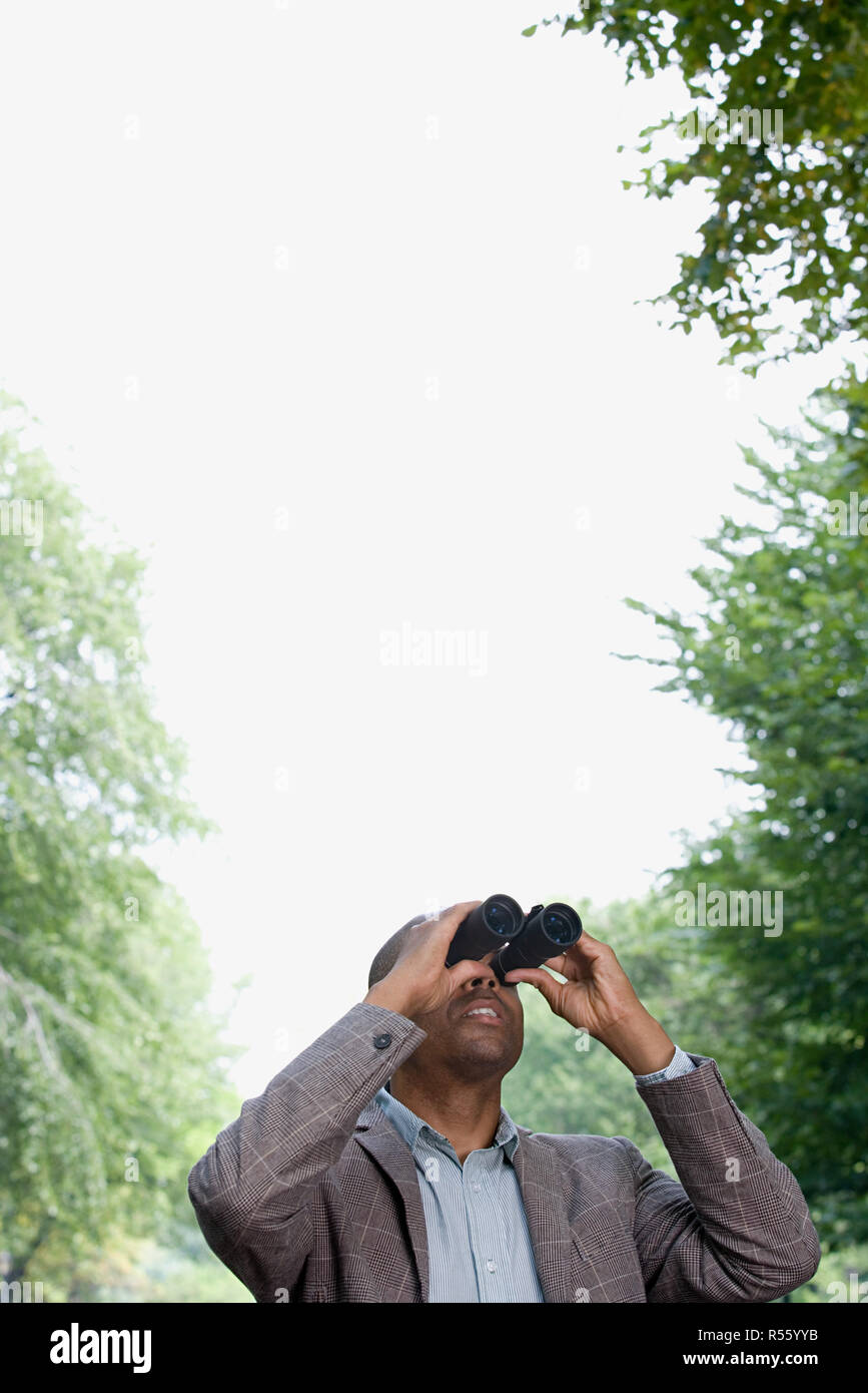 Man looking through binoculars Stock Photo - Alamy