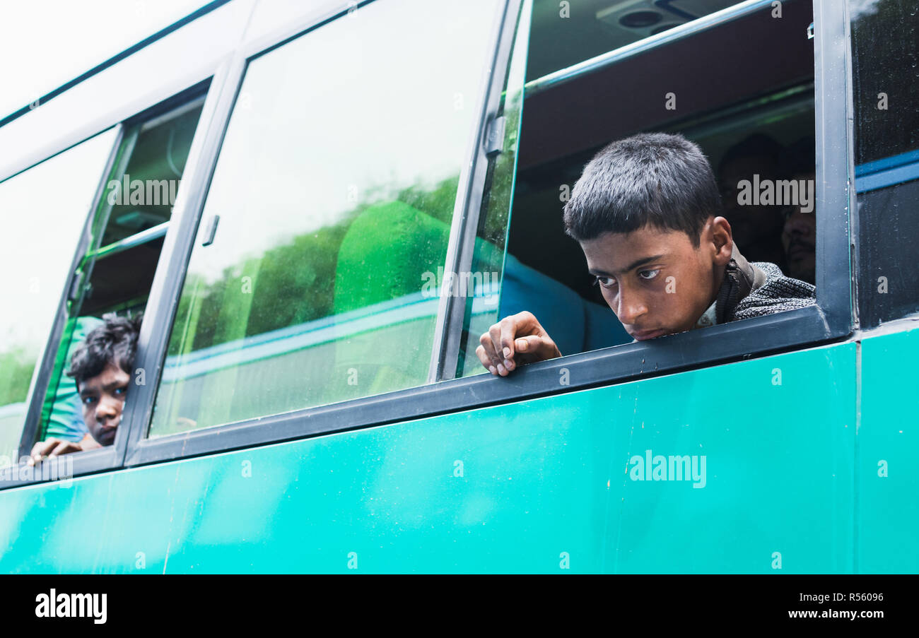 KATHMANDU, NEPAL - APRIL 2015: young sad boy looking out of the bus ...