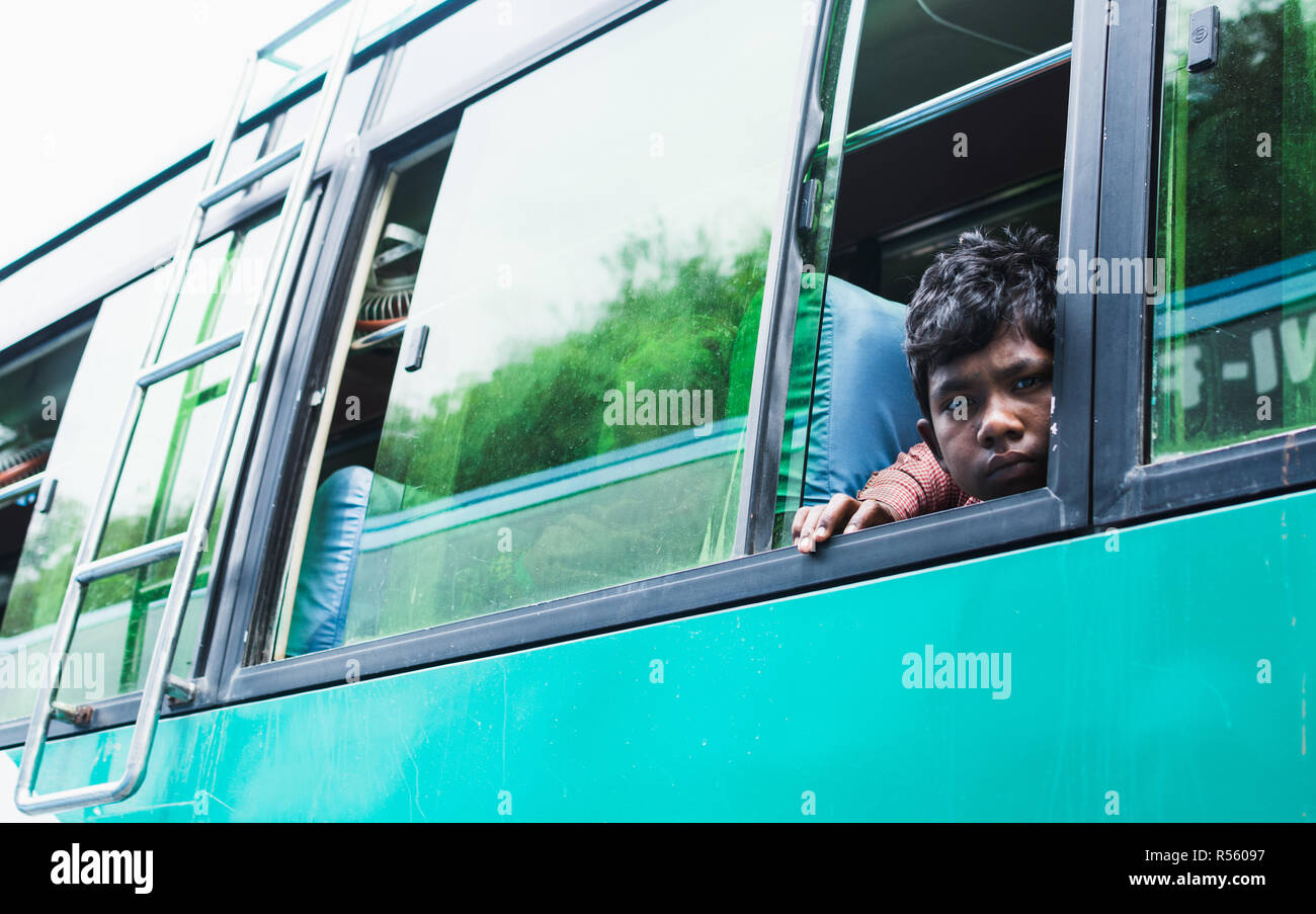 KATHMANDU, NEPAL - APRIL 2015: young sad boy looking out of the bus ...