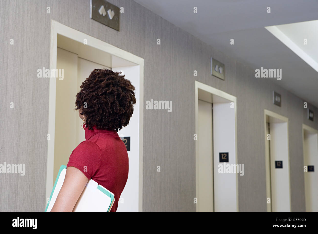 Woman waiting for elevator Stock Photo - Alamy