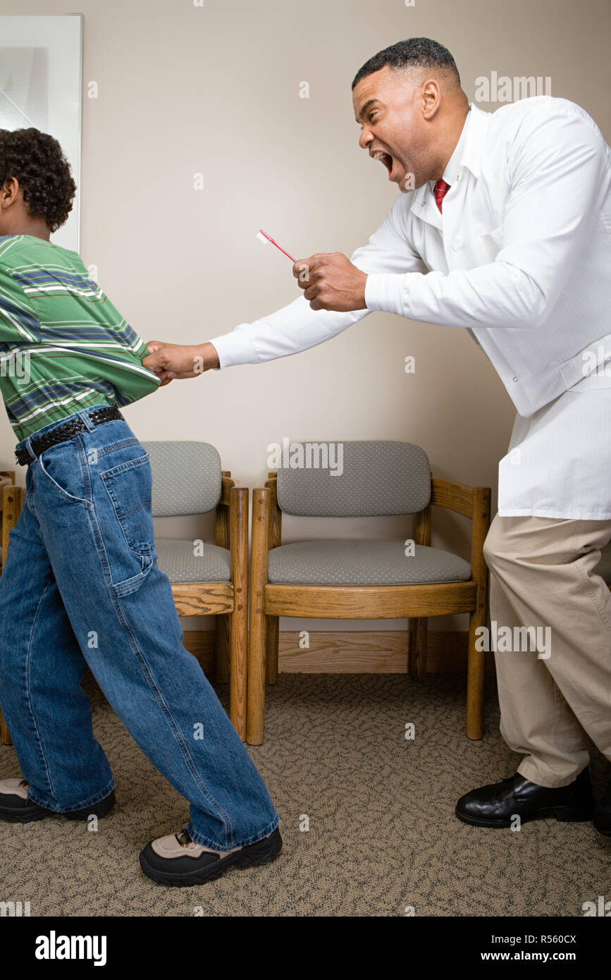 Dentist trying to grab boy Stock Photo - Alamy