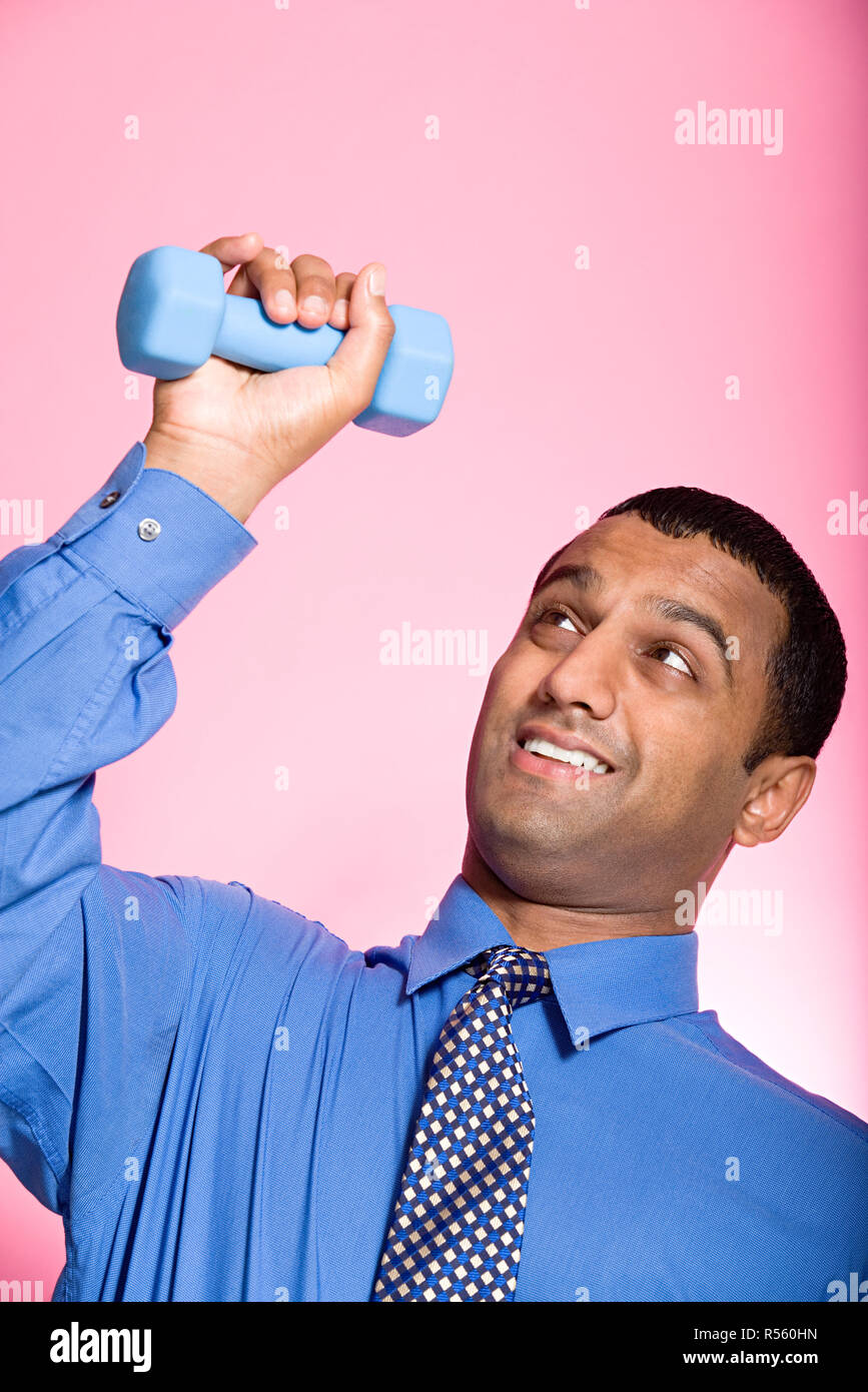 Man struggling to lift a dumbbell Stock Photo - Alamy