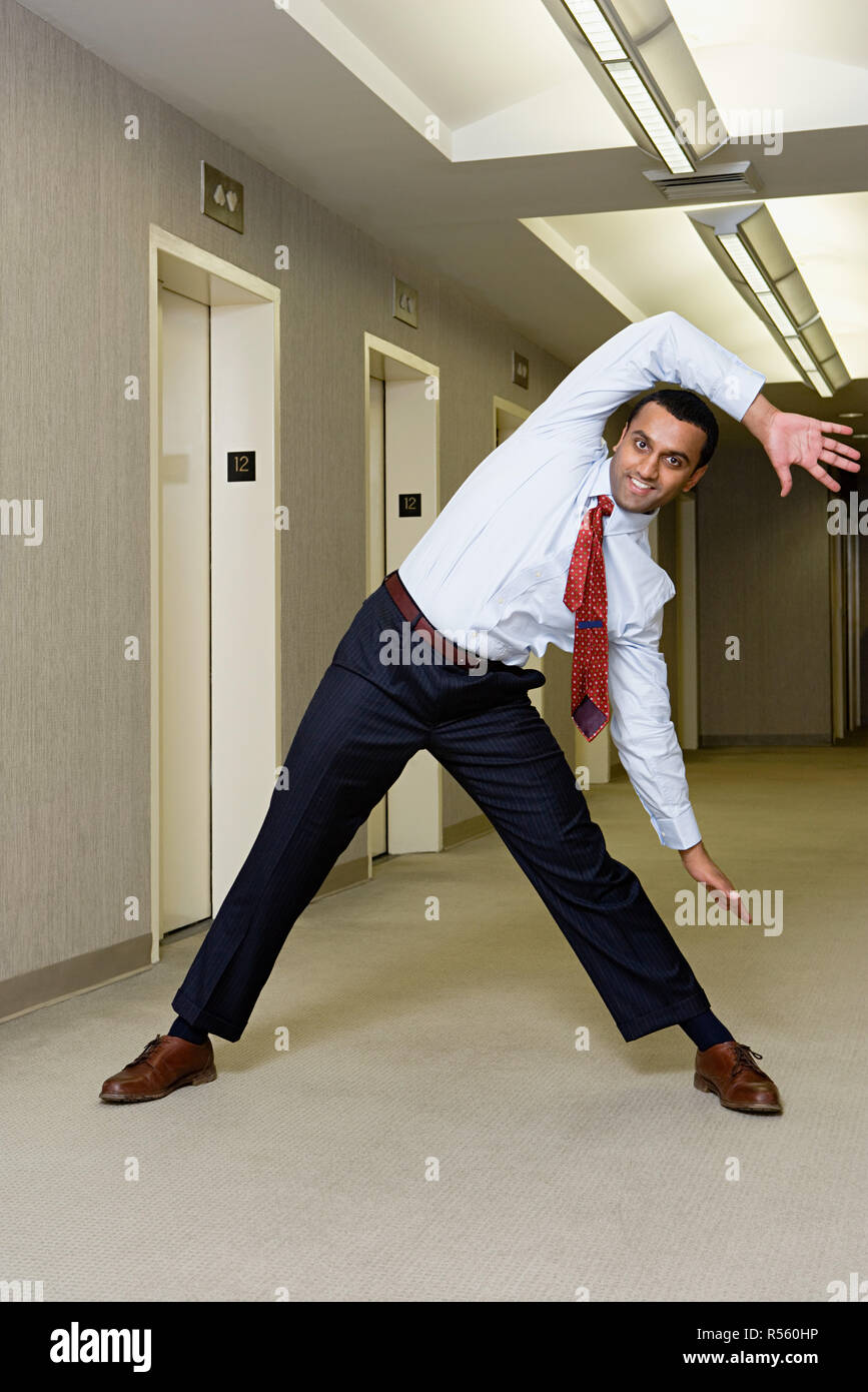 Office worker stretching in corridor Stock Photo - Alamy