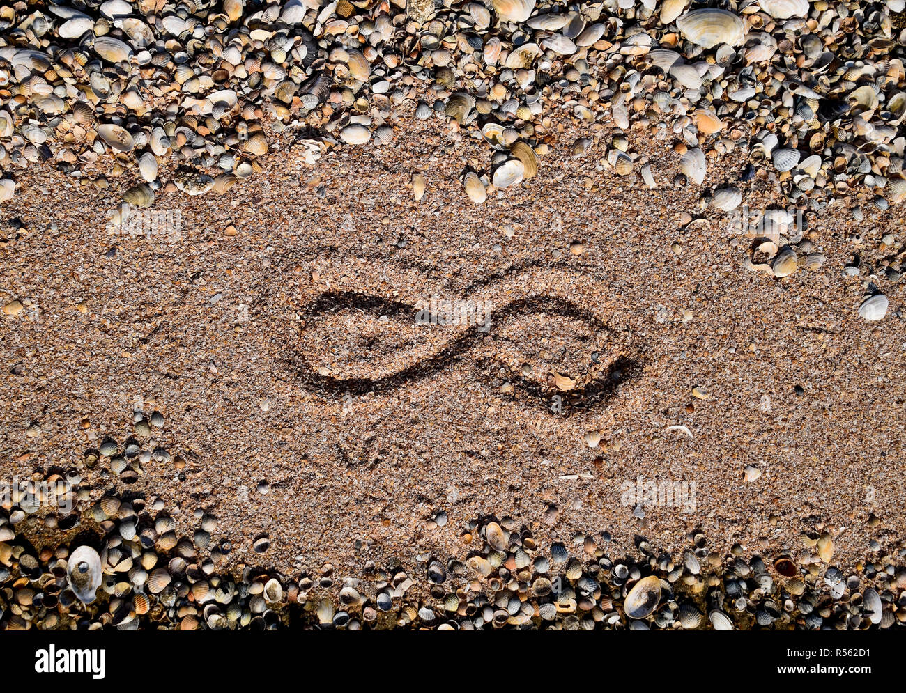 The sign of infinity on the sea. Coastal sand on the beach. The symbol ...