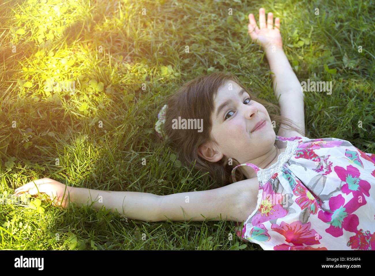 Smiling girl lying on the grass Stock Photo - Alamy