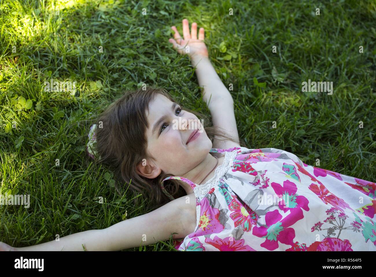 Smiling girl lying on the grass Stock Photo - Alamy