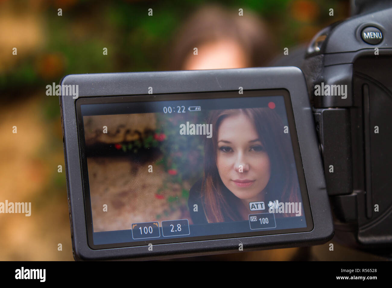 Young woman on camera screen looking at camera Stock Photo - Alamy