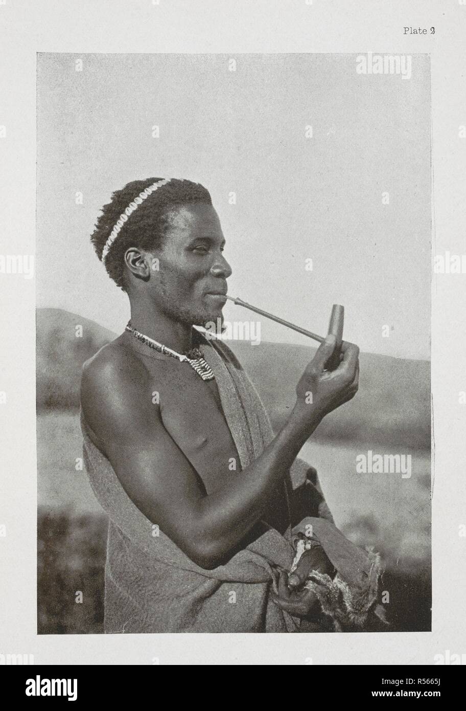 A Bomvava. A man wearing a shell necklace and he is smoking a pipe. The ...