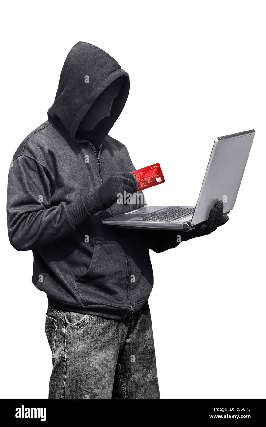 Hacker man wearing anonymous mask holding laptop and credit card while ...