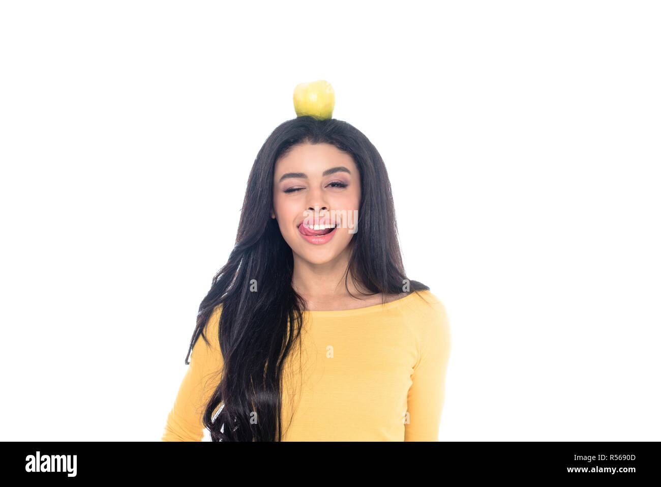 happy african american girl with apple on head licking lips isolated on ...
