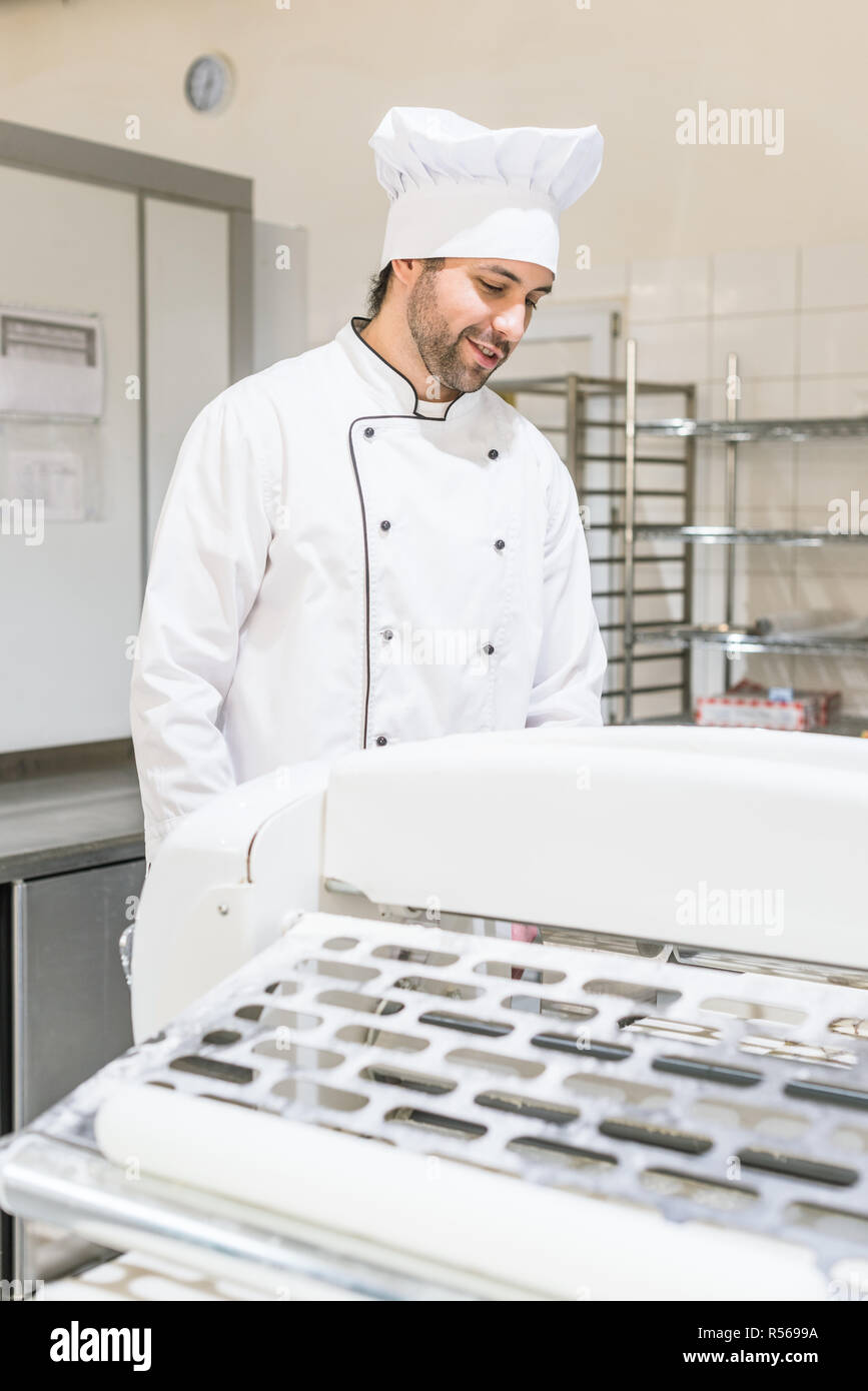 Handsome baker in chef uniform in bakehouse kitchen Stock Photo - Alamy