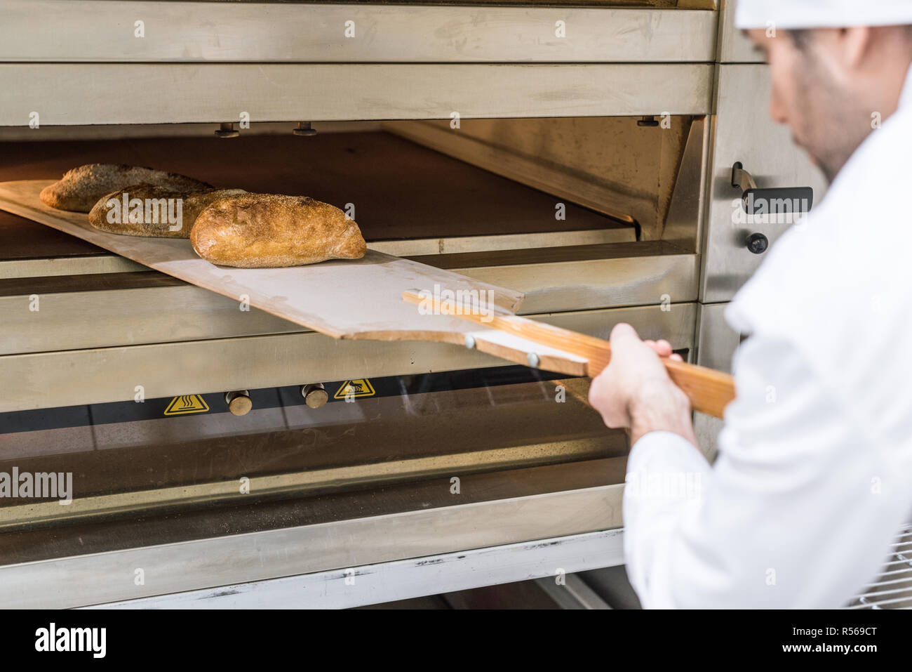 Taking bread out of the oven hi-res stock photography and images - Alamy