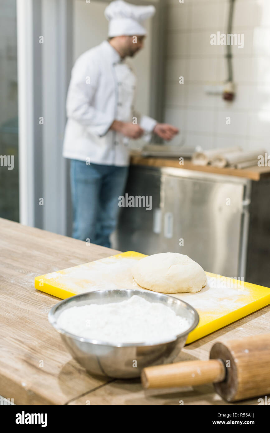 adult baker in chefs uniform preparing dough at counter Stock Photo - Alamy