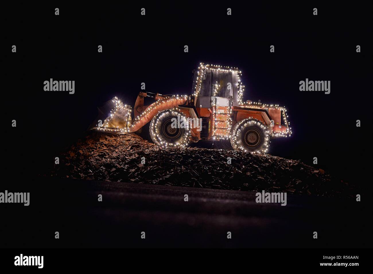 Blurred wheel loader decorated with lights Stock Photo - Alamy
