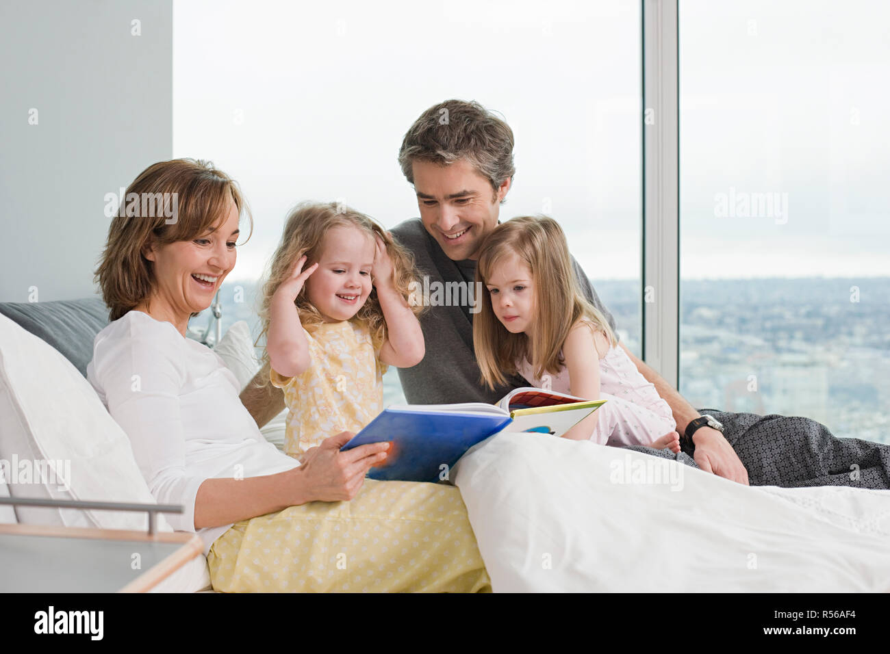 family reading a book Stock Photo - Alamy