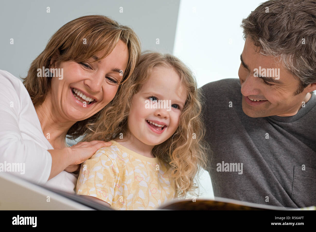 family reading a book Stock Photo - Alamy