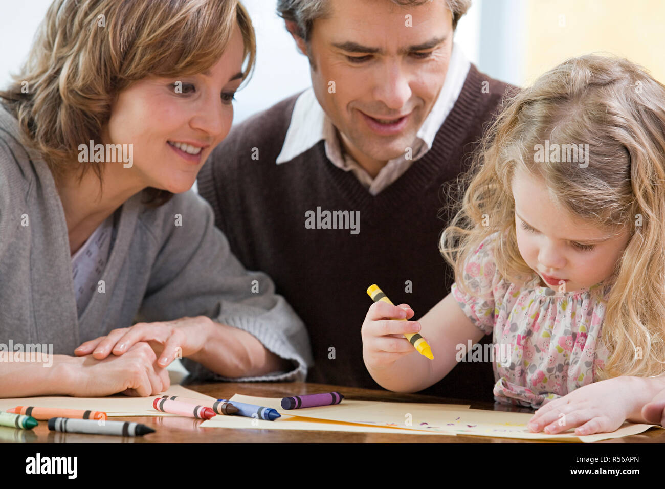Parents helping their daughter draw Stock Photo - Alamy