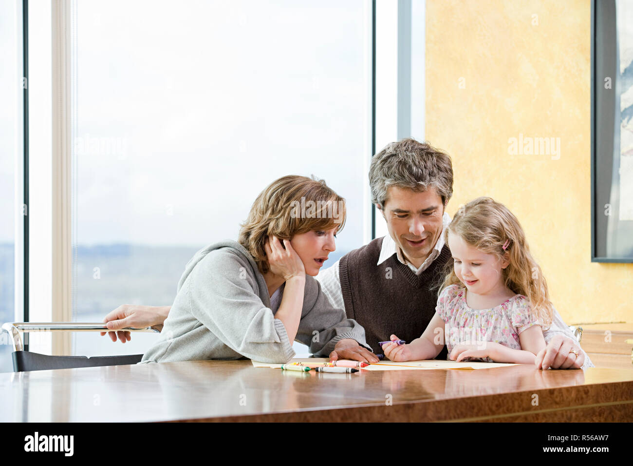 Parents helping their daughter draw Stock Photo - Alamy