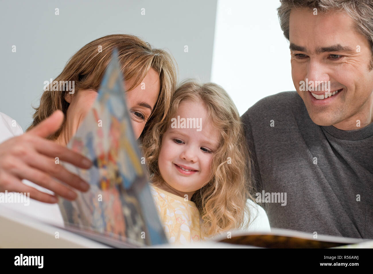 family reading a book Stock Photo - Alamy