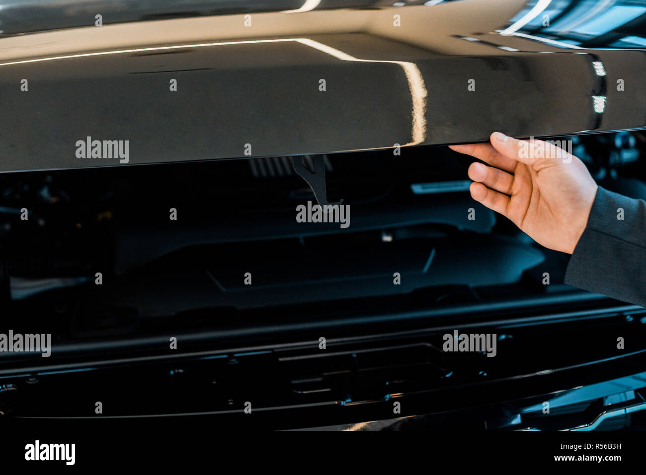 cropped image of businessman opening car hood of black automobile Stock ...