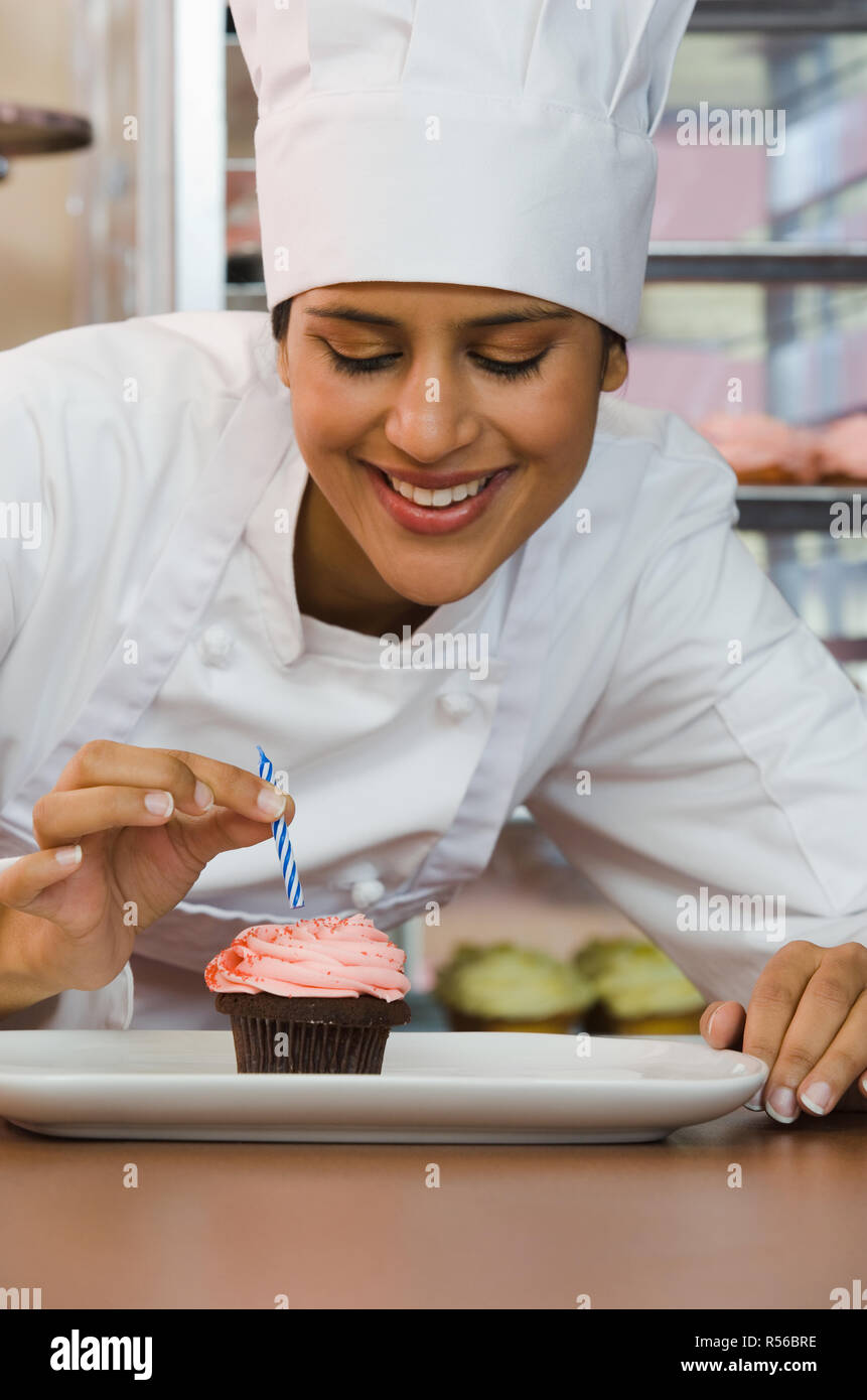 Baker with cupcake and candle Stock Photo - Alamy