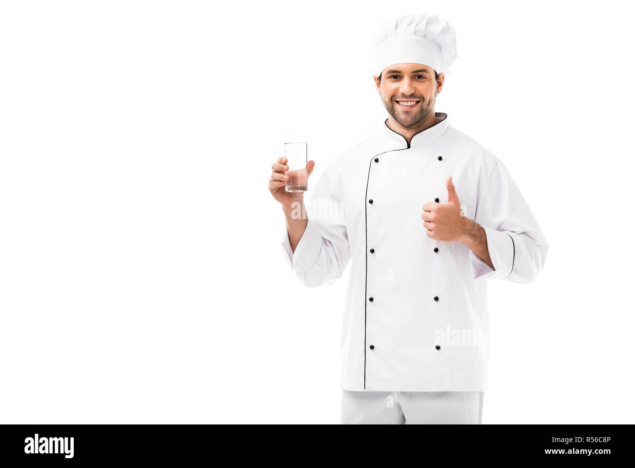 smiling young chef with glass of water showing thumb up isolated on ...