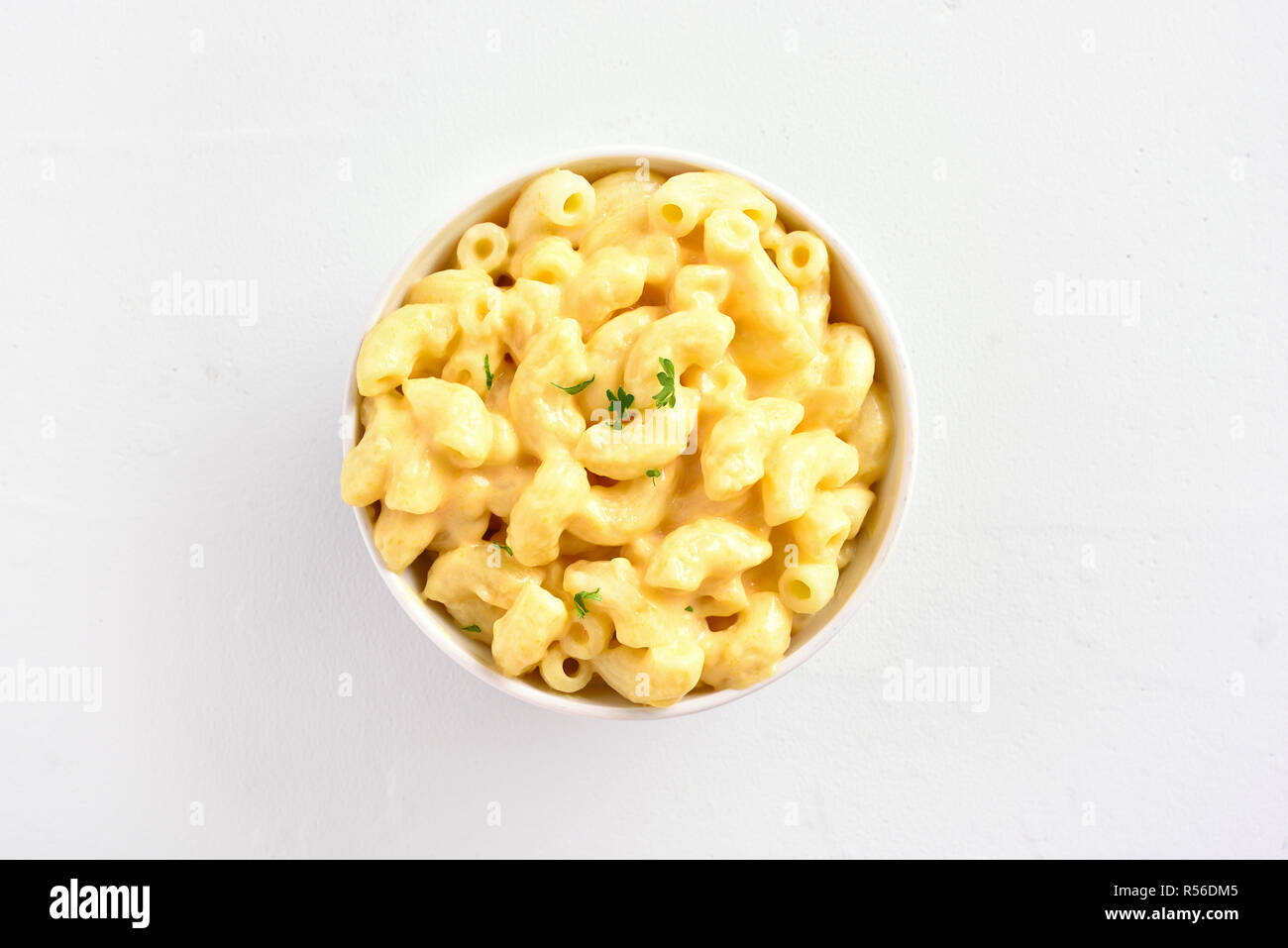 Macaroni and cheese in white bowl on white stone background with copy ...