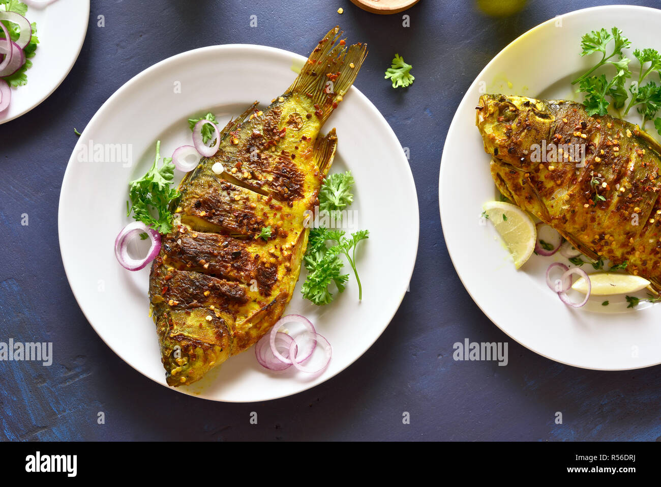 Grilled fish on plate over blue stone background. Top view, flat lay ...