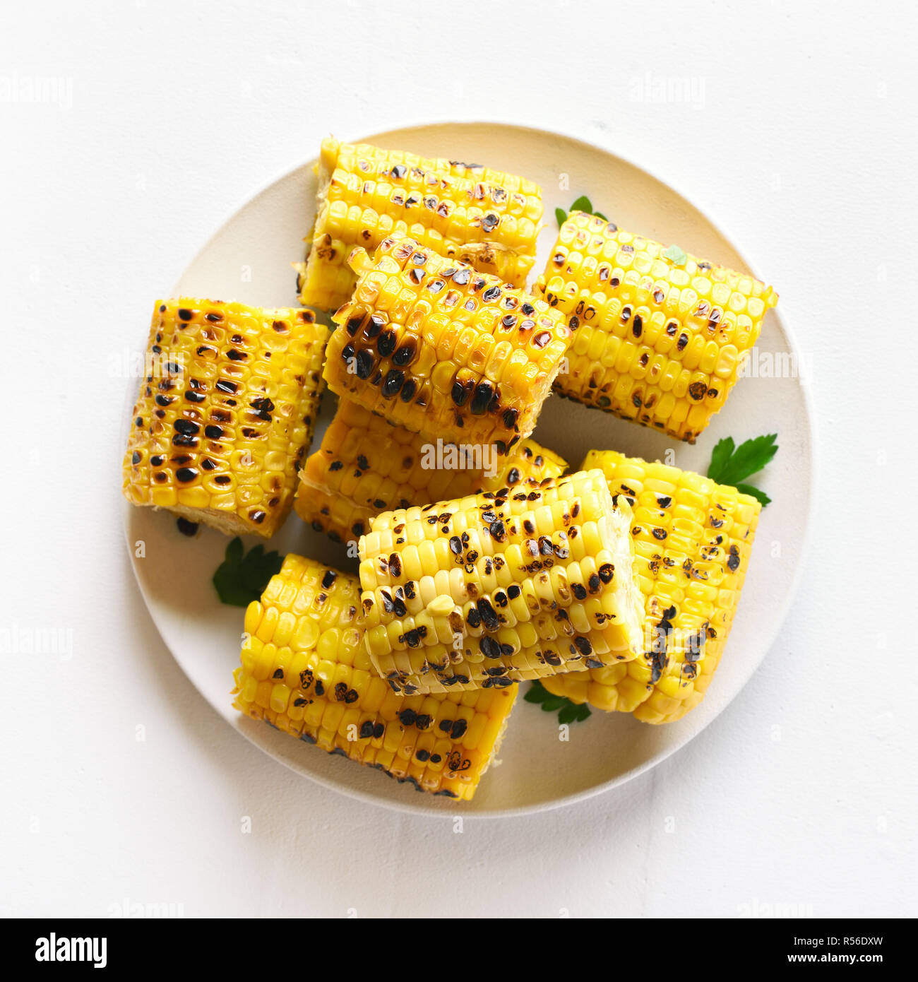 Grilled corn cobs on plate over white stone background. Tasty ...