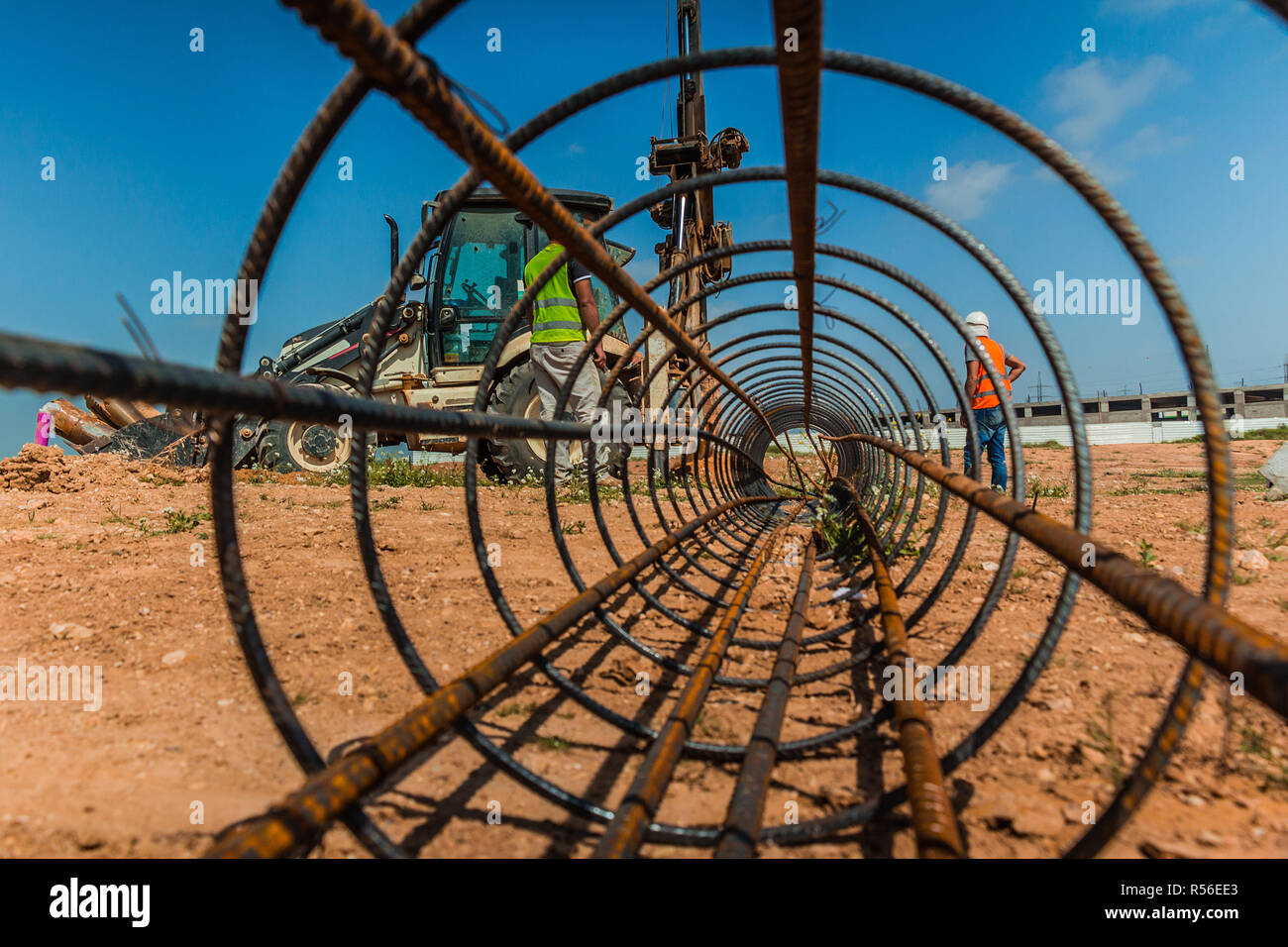 Workers and a tractor with a drilling device at a construction site ...