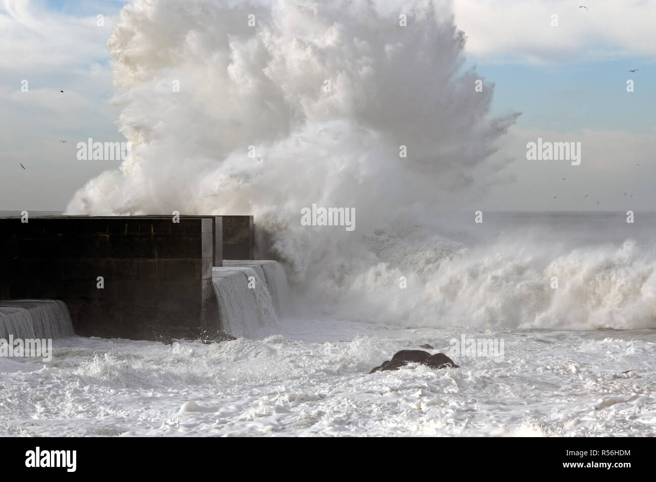 Great ocean wave crashing against pier in Portugal Stock Photo - Alamy