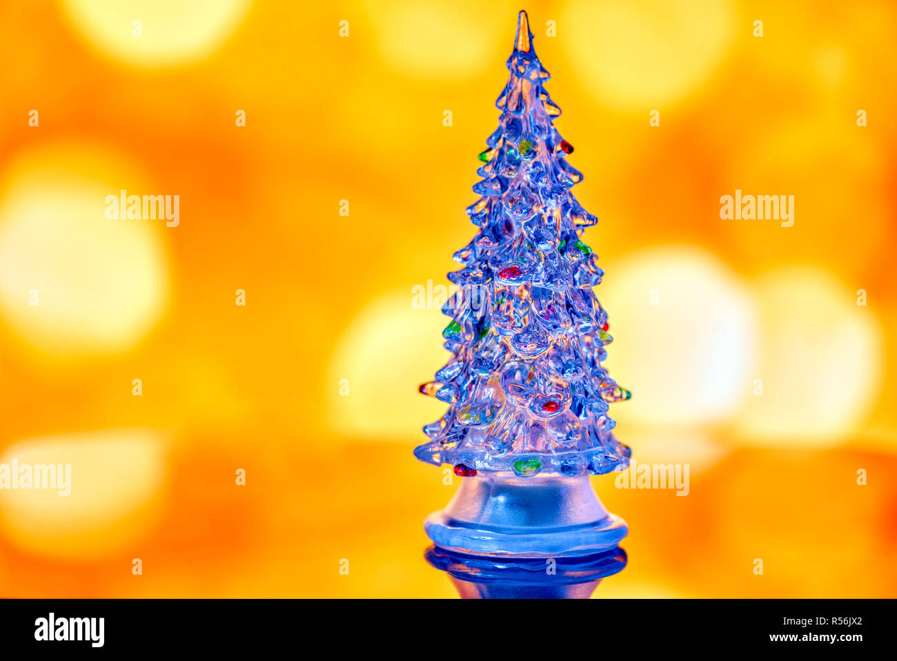 Miniature transparent Christmas tree isolated on golden bokeh light ...
