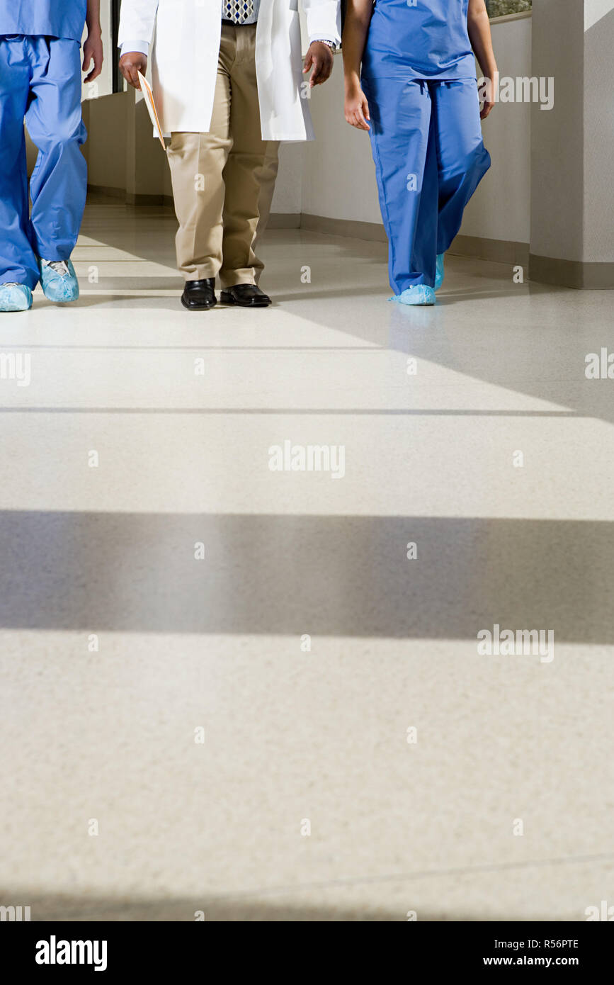Doctors walking down corridor Stock Photo - Alamy