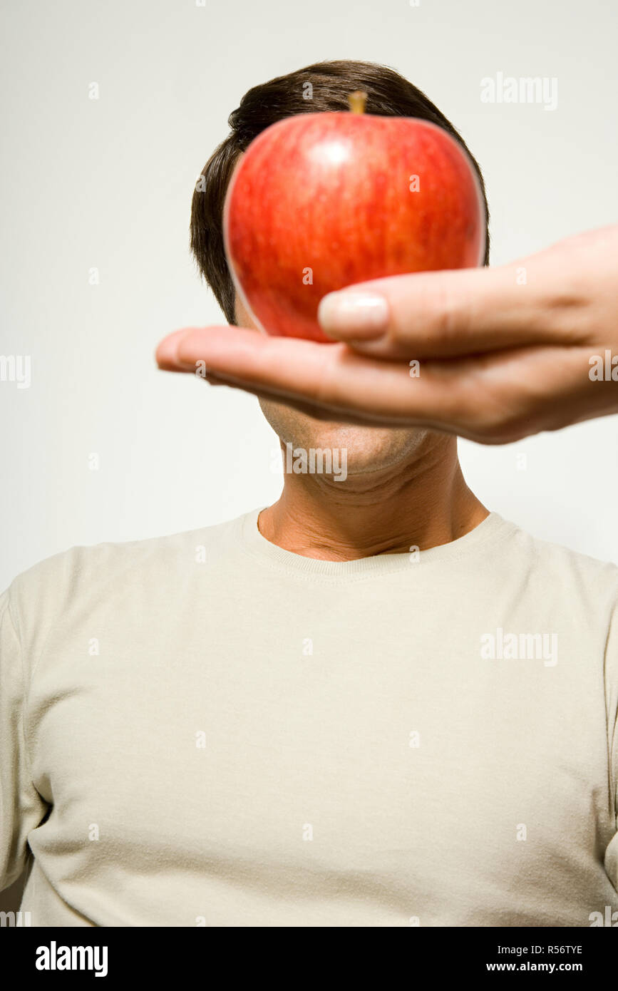 Woman holding apple over man's face Stock Photo - Alamy