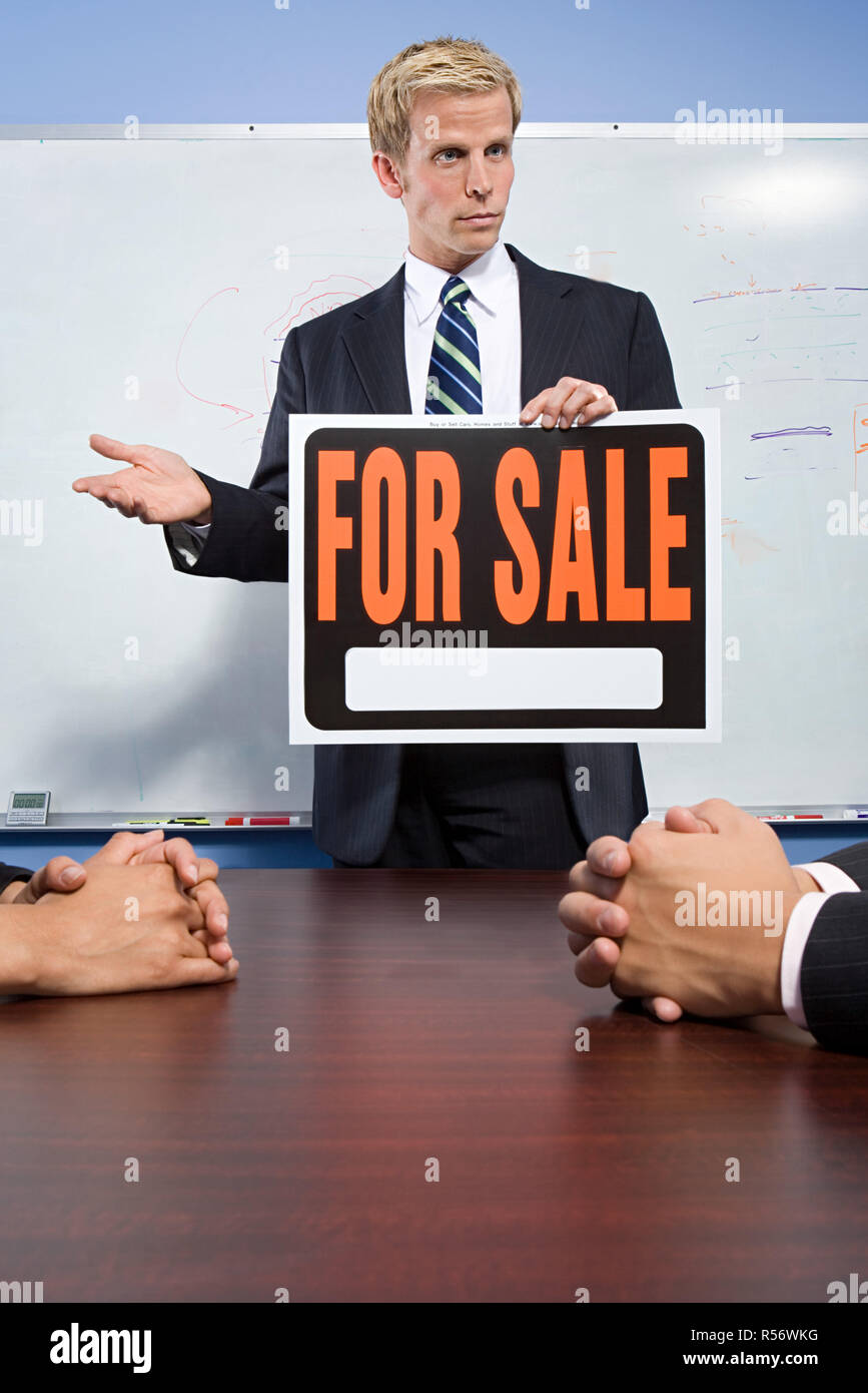 Businessman holding for sale sign Stock Photo - Alamy