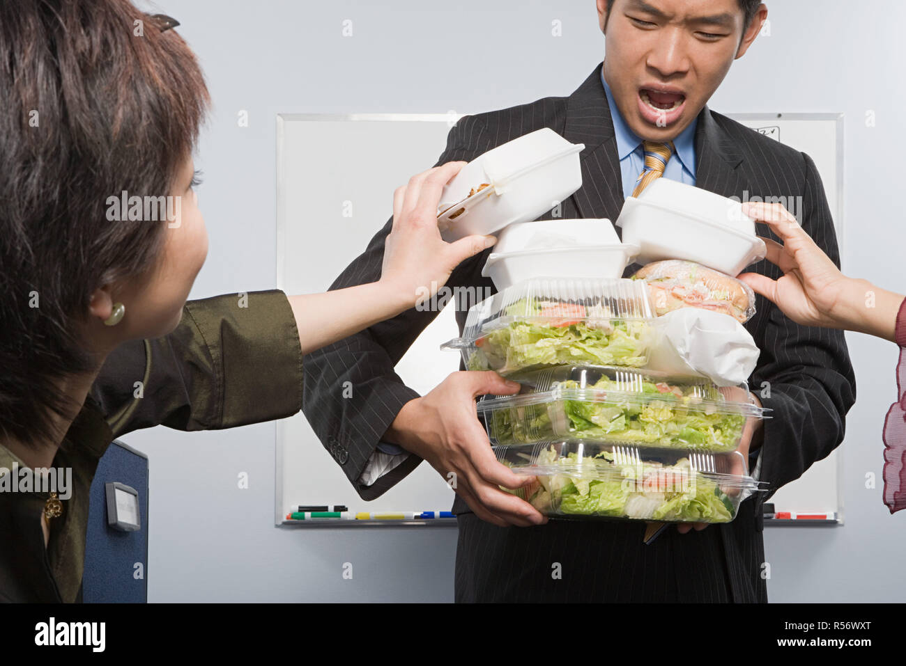 People taking food from colleague Stock Photo - Alamy