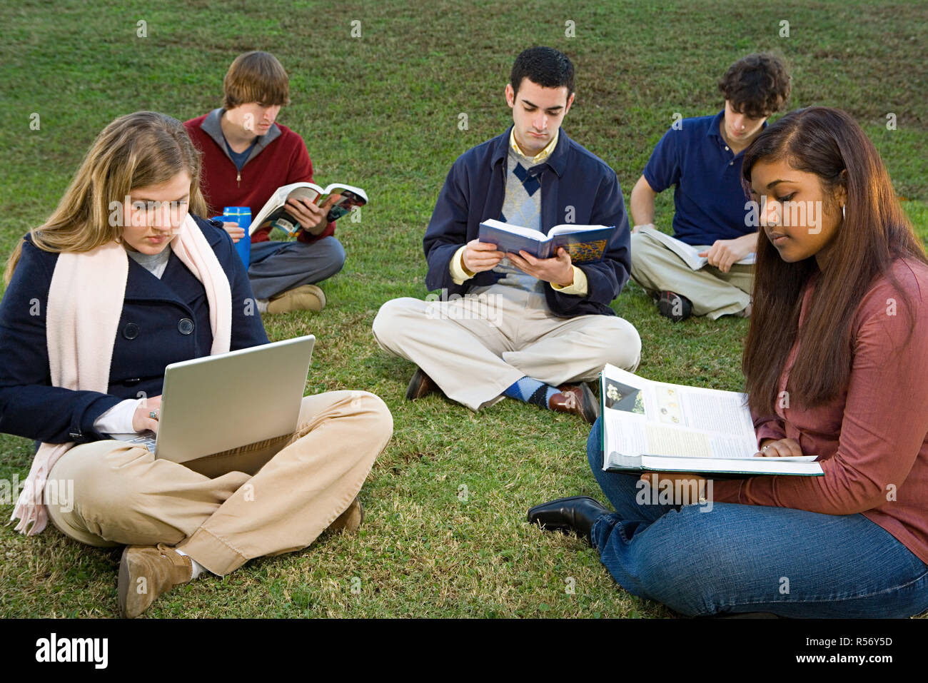 Five students sat reading outdoors Stock Photo - Alamy